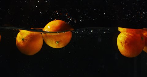 Orange Falling Into Water Against Black Stock Footage Video (100% ...