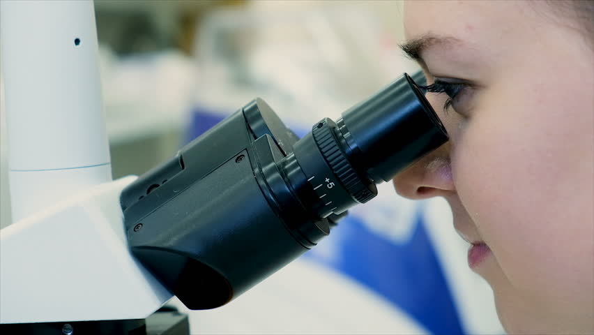 scientist looking through microscope examining new Stock Footage Video ...