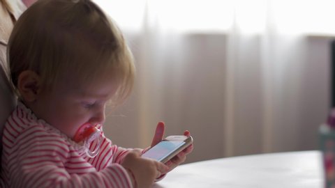 Little Girl Pacifier Playing Phone Stock Footage Video (100% Royalty ...