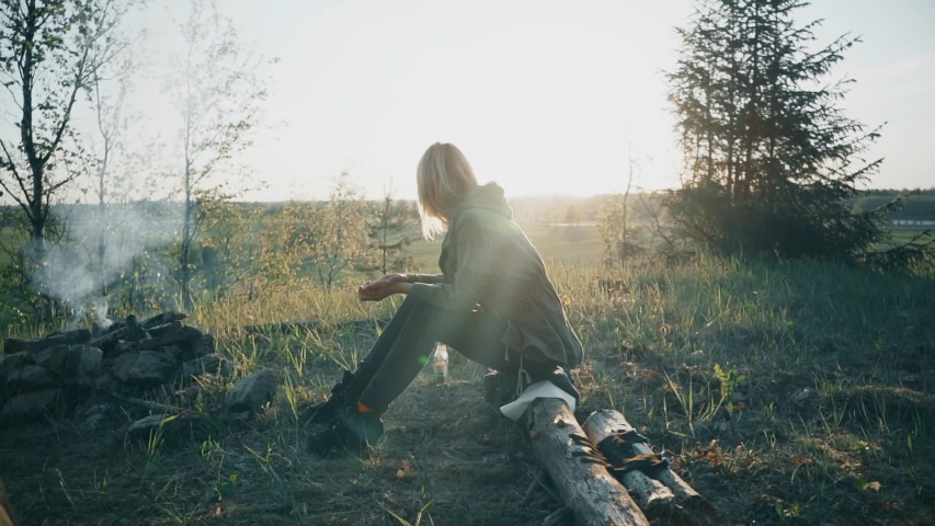 girl sitting front fire amazing sunset Stock Footage Video (100% ...