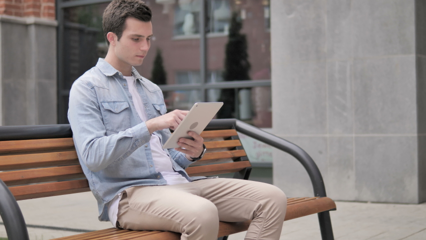 casual young man sitting outdoor using Stock Footage Video (100% ...
