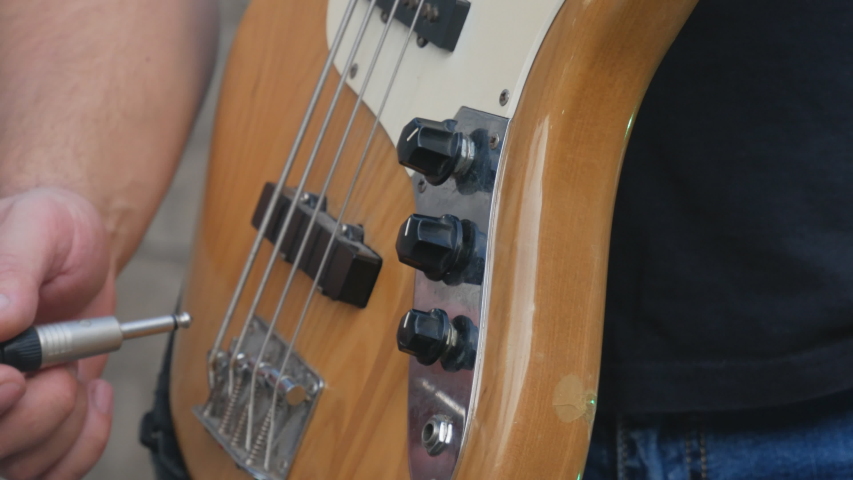 guitarist's hand inserts cable into electric Stock Footage Video (100% ...