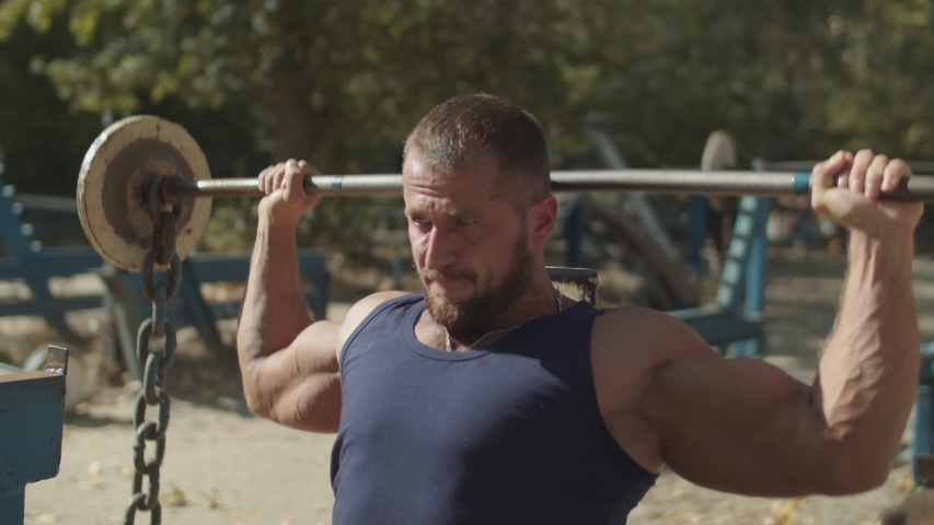 determined strong bodybuilder exercising behind neck Stock Footage ...