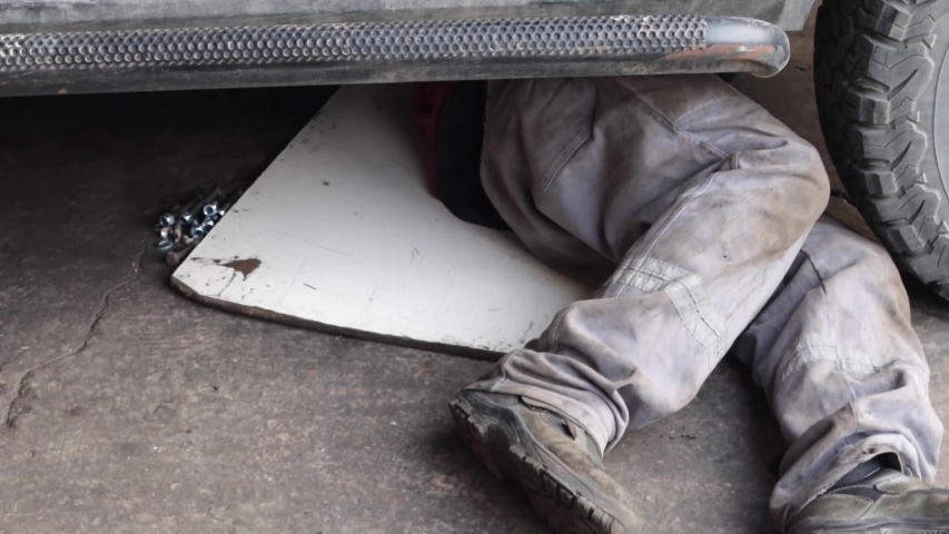 mechanic uniform lying down working under Stock Footage Video (100% ...