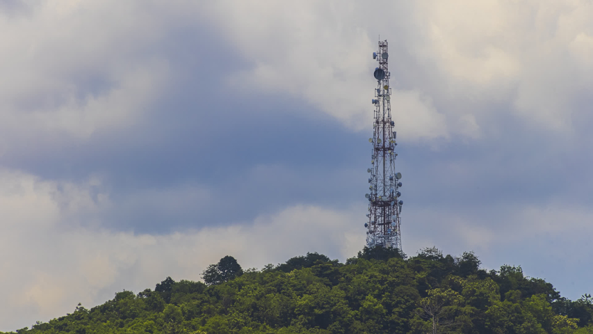 Rotating aerial view of 5G telecommunication towers standing tall on ...