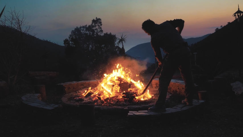 silhouette man stoking fire bonfire burning Stock Footage Video (100% ...