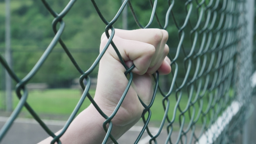 hand shakes mesh fence clenching fist Stock Footage Video (100% Royalty ...