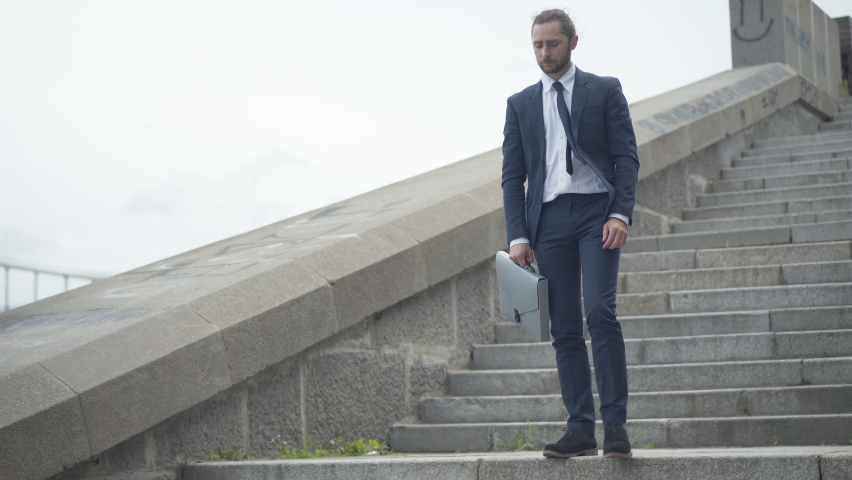 young overworked businessman walking down stairs Stock Footage Video ...