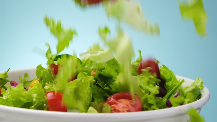 fresh salad falling bowl on blue Stock Footage Video (100% Royalty-free ...