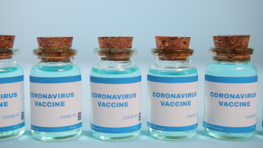 Wide shot. Front view. Doctor draws up syringe with COVID-19 vaccine on ...