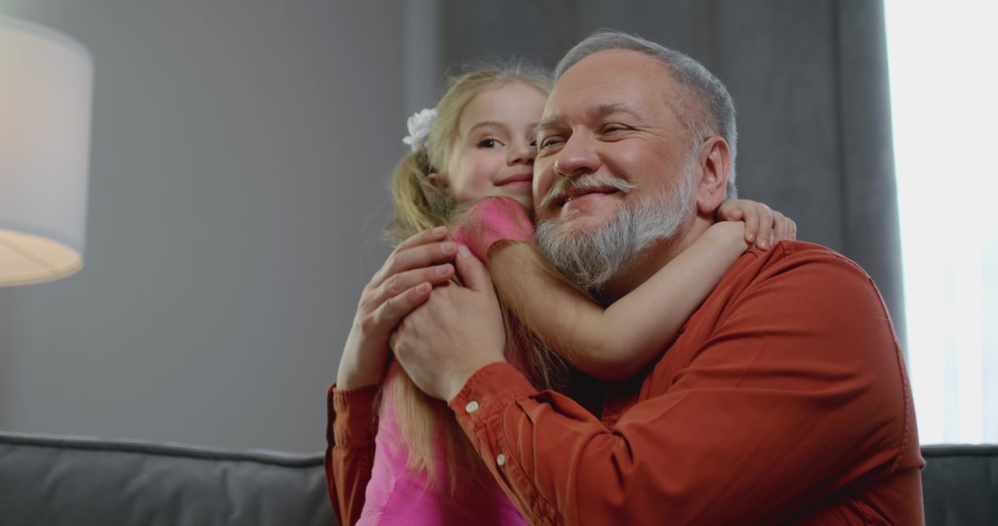 Mature african american father hugging little daughter tightly dad and kid girl spend time ...