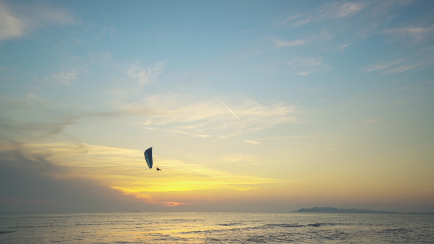 Amazing aerial video of flying paraglider on the background of wild nature. Paraplan drifting ...