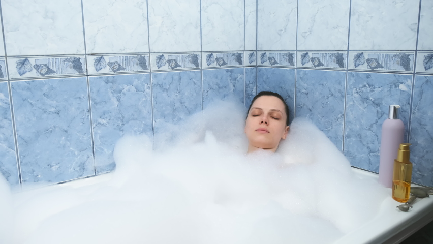 Upset woman lying in bath with foam bubbles, relieving stress, life ...