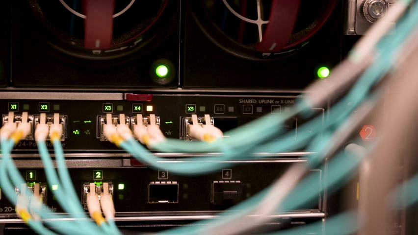 LED lights in a server rack with RJ45 and fiber optic cable connectors ...