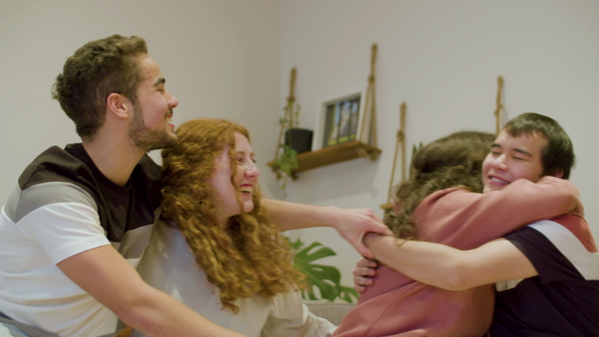 Happy excited soccer fans sitting at home with Qatar flags and cheering ...