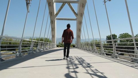Young Man Crossing Bridge Back View Stock Footage Video (100% Royalty ...