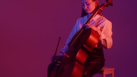 Girl Sitting Playing Cello On Neon Stock Footage Video (100% Royalty ...