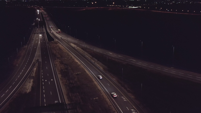 Aerial view of expressway traffic at night, and crossing of bridges and ...