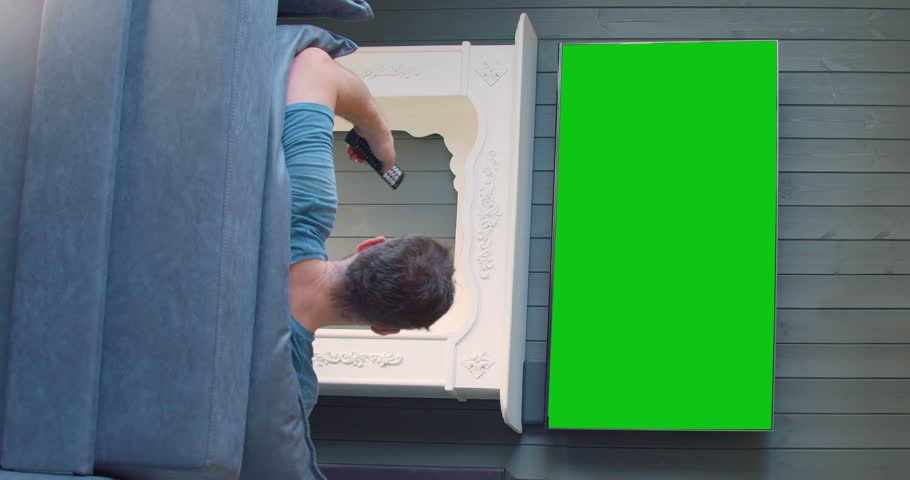 Changing Channels Big Green Screen Television Man Using TV Remote. Back ...