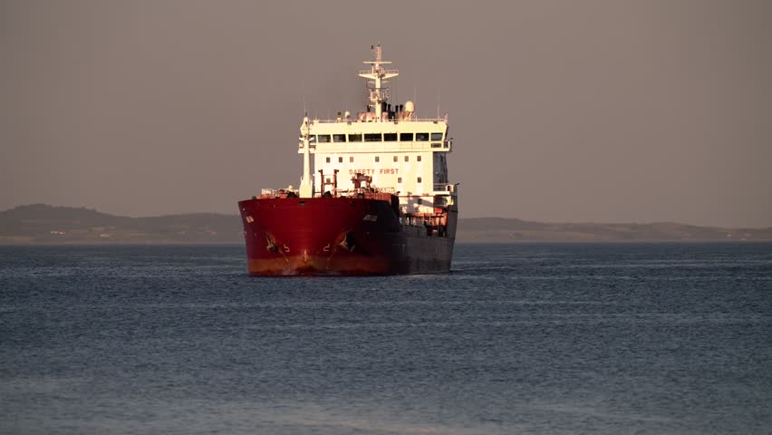 Aerial footage of red colour ultra large empty container ship at sea ...