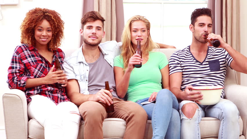 smiling friends watching tv while eating Stock Footage Video (100% ...