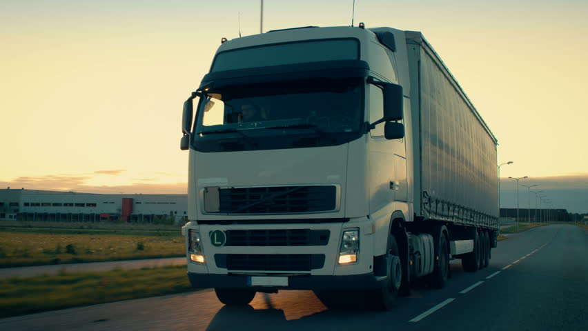 Back view camera follows American semi truck with 40 foot container ...