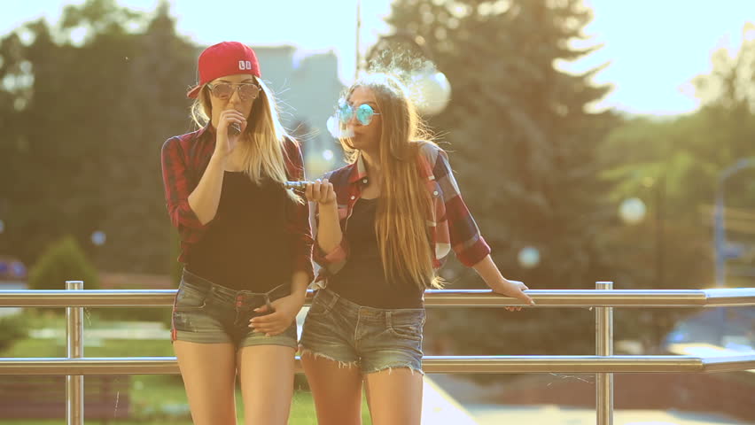 two women vaping outdoor evening sunset Stock Footage Video (100% ...