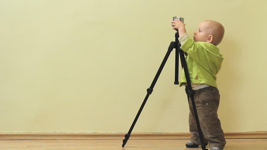 baby standing near tripod looking photo Stock Footage Video (100% ...