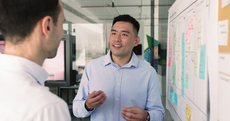 Chinese man leads conversation to male colleague, explain tasks details ...