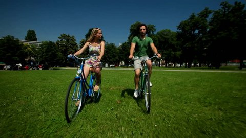 Young Couple Enjoying Cycling Through Park Stock Footage Video (100% ...