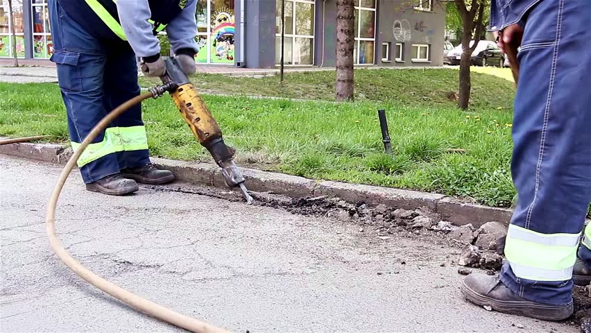 worker shovel collects broken asphalt behind Stock Footage Video (100% ...