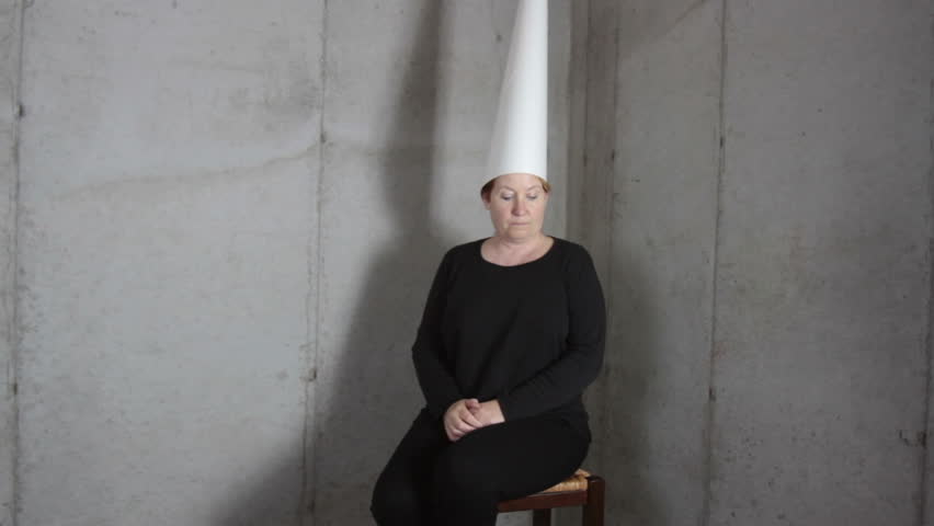 woman wearing dunce cap sitting on Stock Footage Video (100% Royalty ...